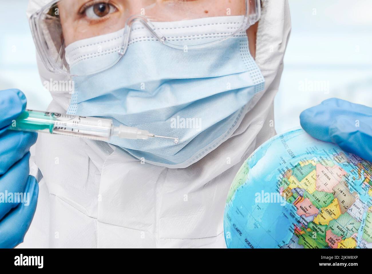 A doctor injecting syringe of Coronavirus vaccine on the planet earth ...
