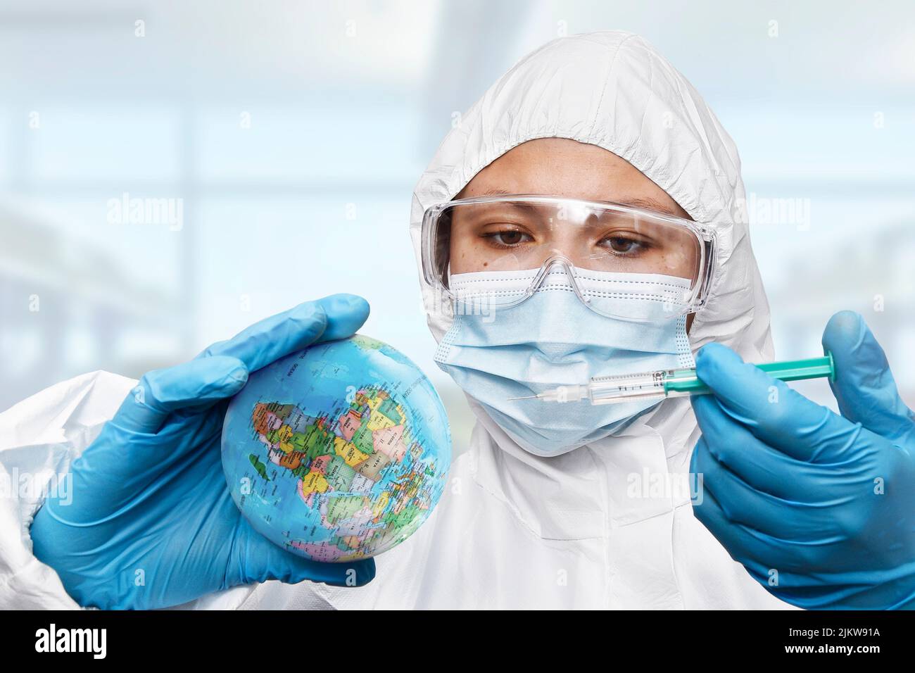 A doctor injecting syringe of Coronavirus vaccine on the planet earth ...