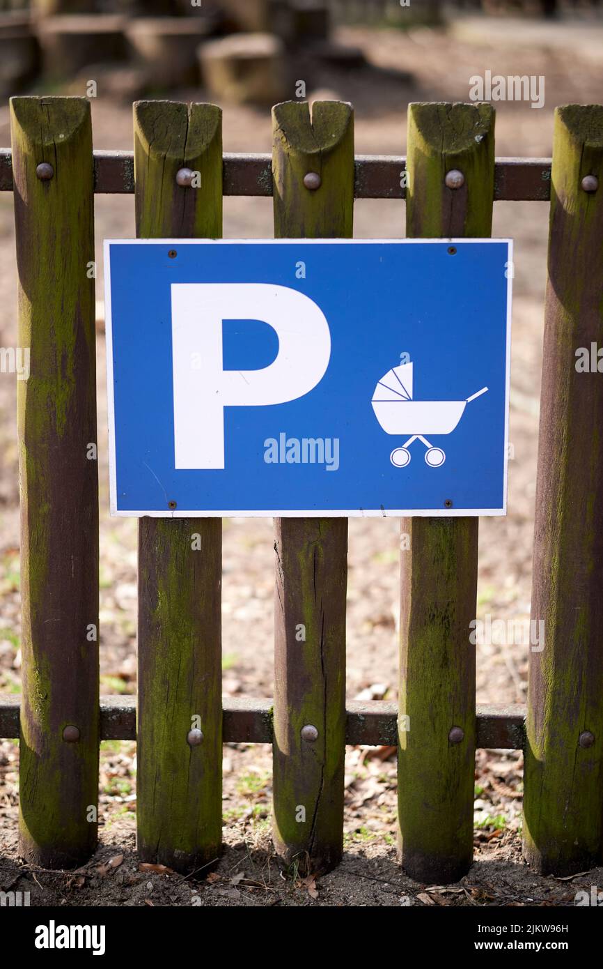 A blue information sign of parking and baby stroller icons on a wooden ...