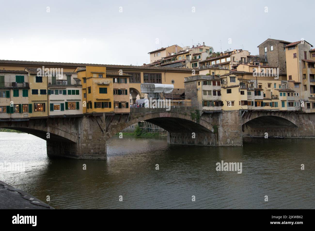 The historic Ponte Vecchio bridge with an outdoor market and buildings ...