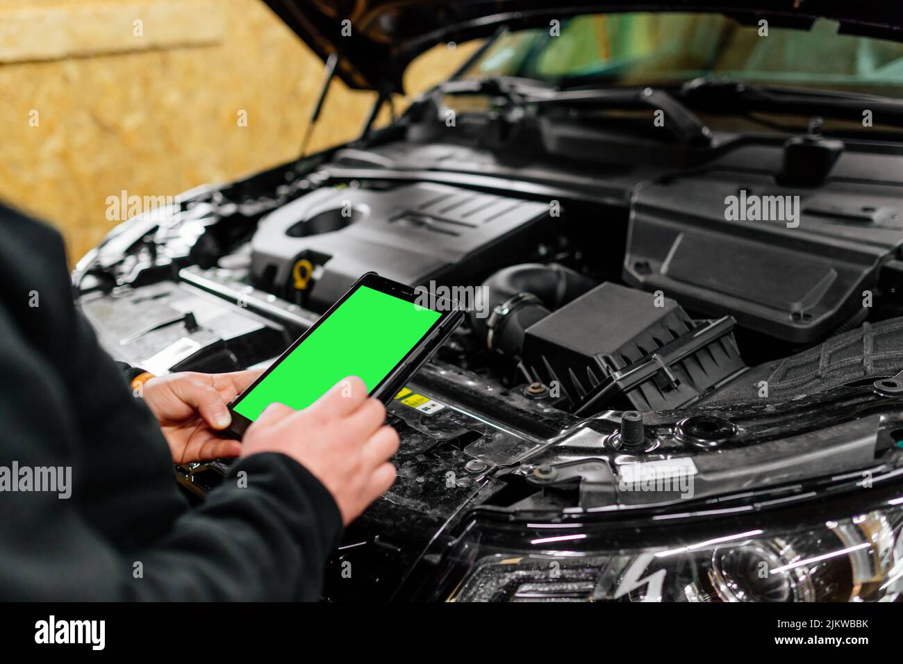 Car mechanic with tablet doing diagnostics detecting malfunction ...