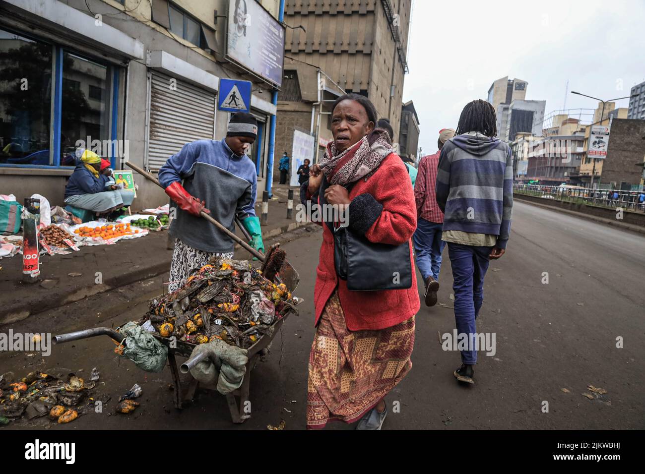 Pedestrians walk past hawkers selling their products by the streets of ...