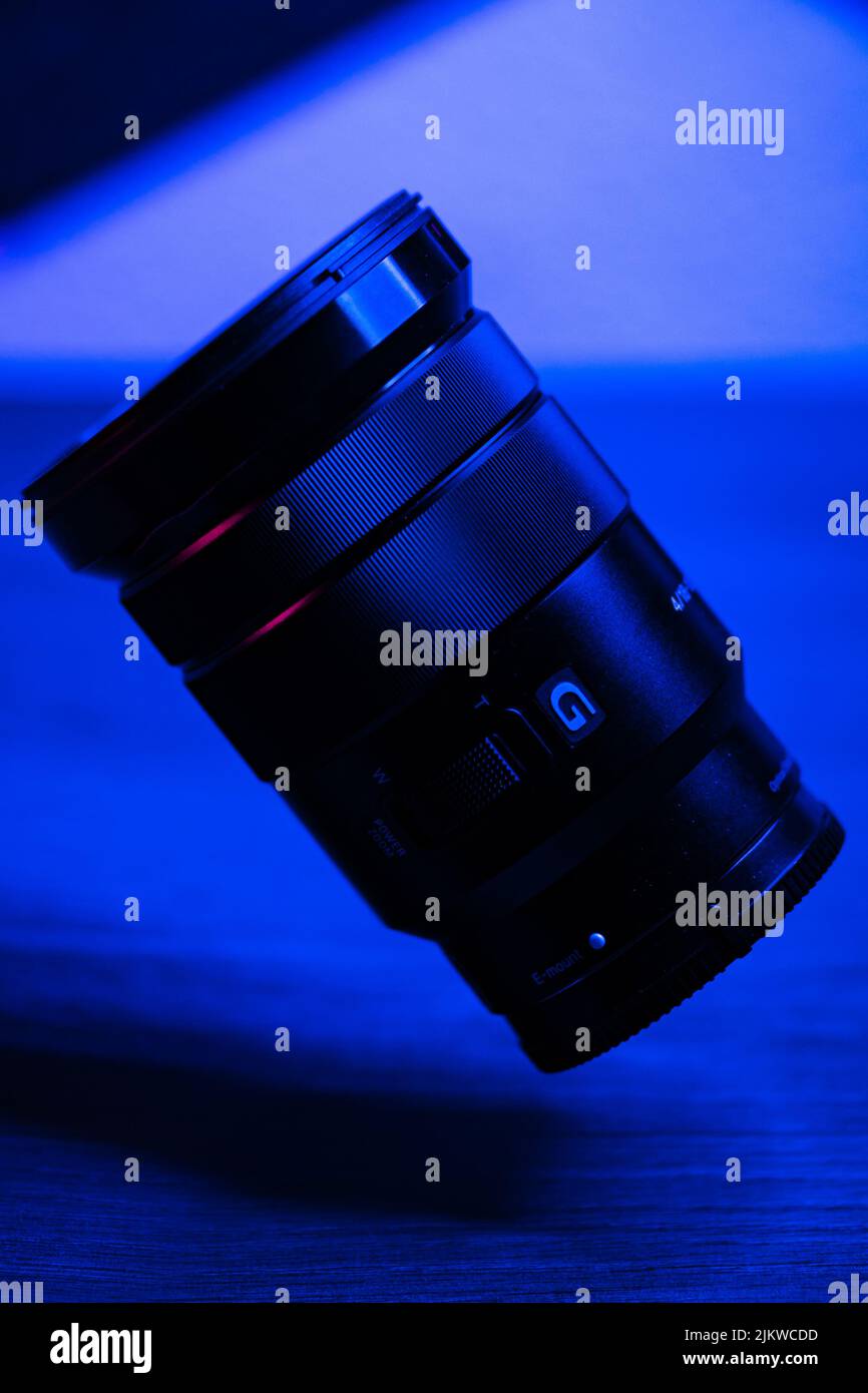 A vertical shot of a floating Sony G Master zoom lens under blue ...