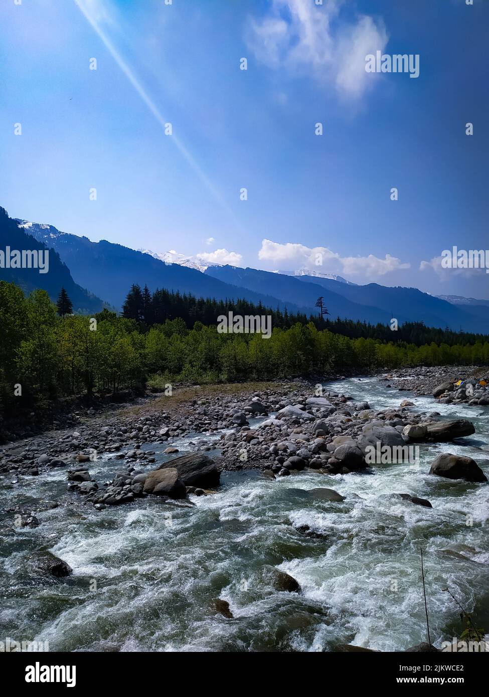 A scenic view of rocky stream with mountain layers in the distance at ...