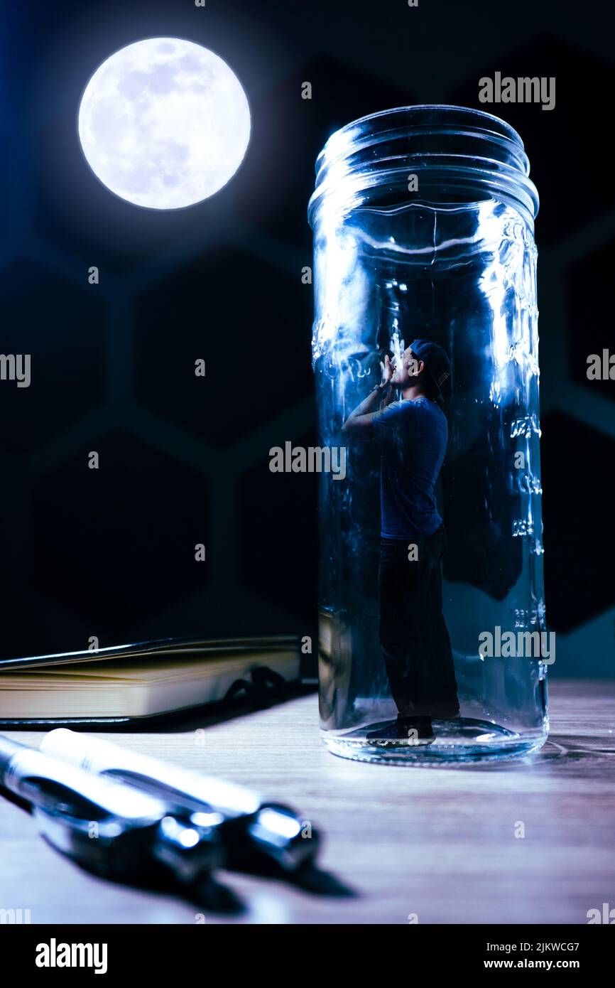 A vertical concept image of a male stuck in a glass jar taking a photo ...