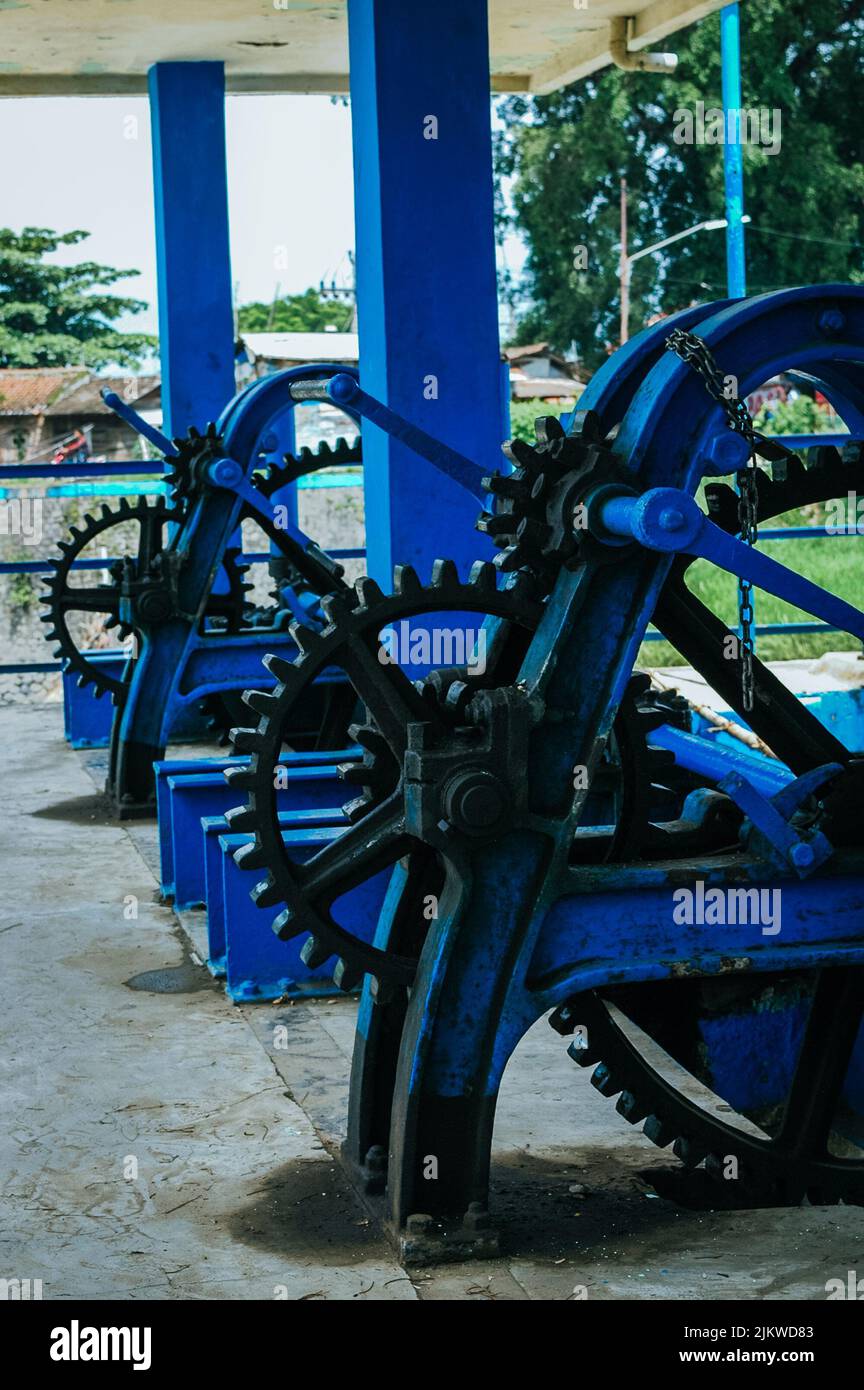 Outdoor blue machines with black gears on a station in a rural village ...