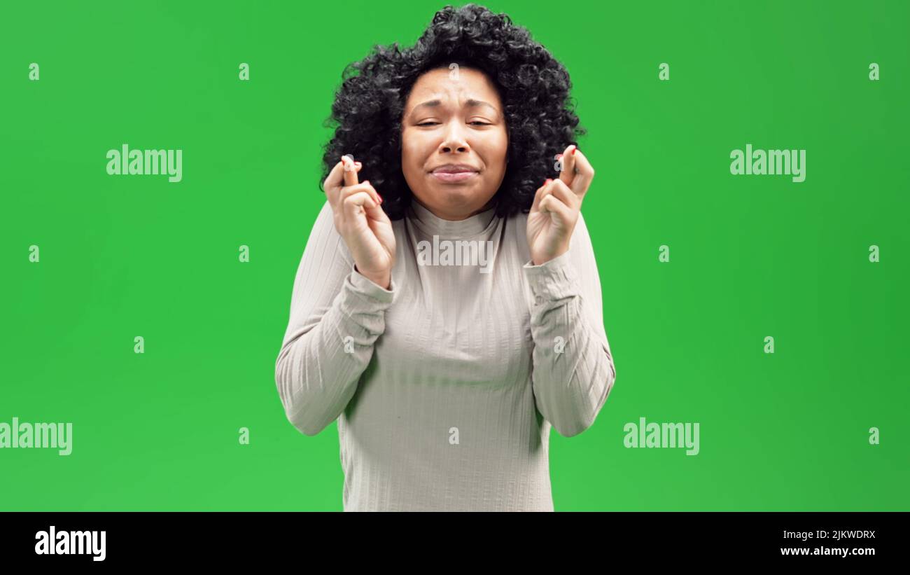 An African American young woman standing on a green chroma background ...