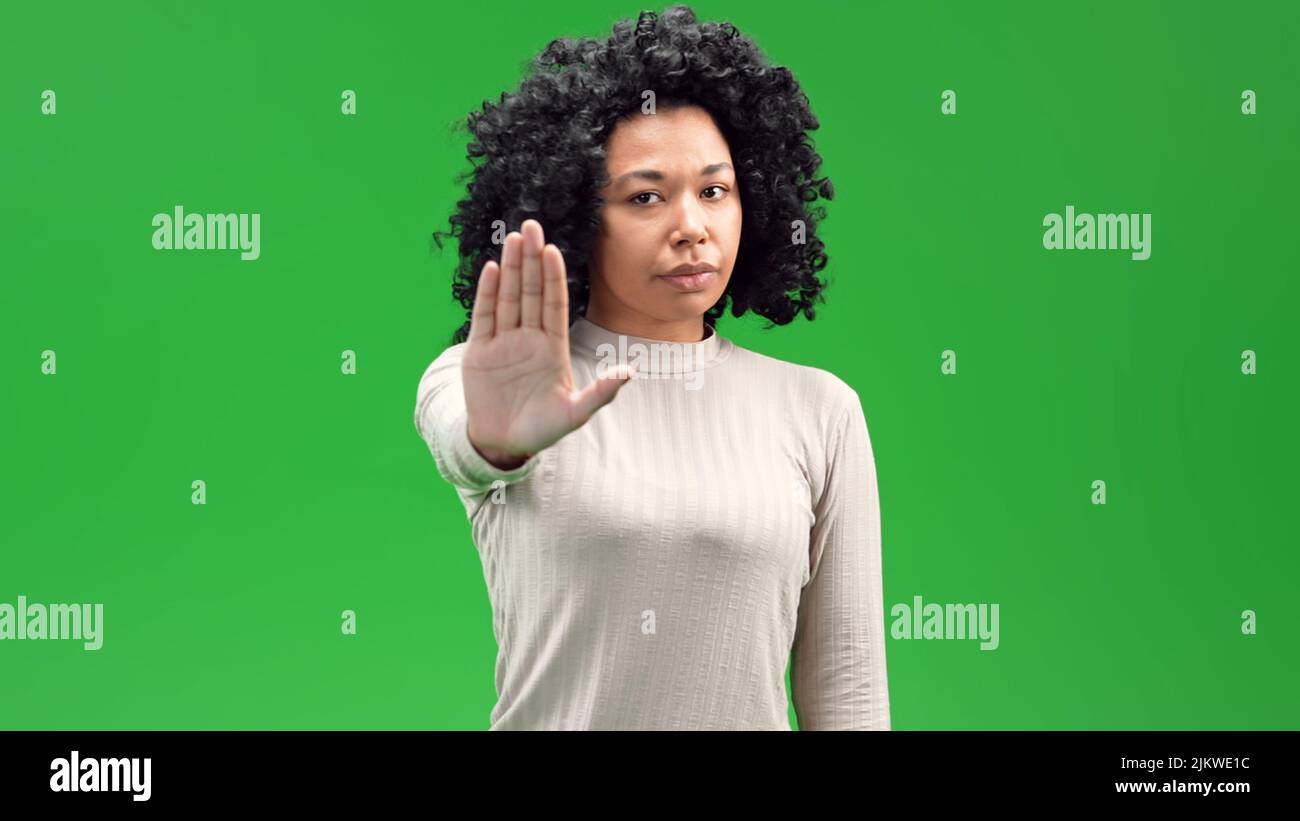 An African American woman standing on a green chroma background with ...