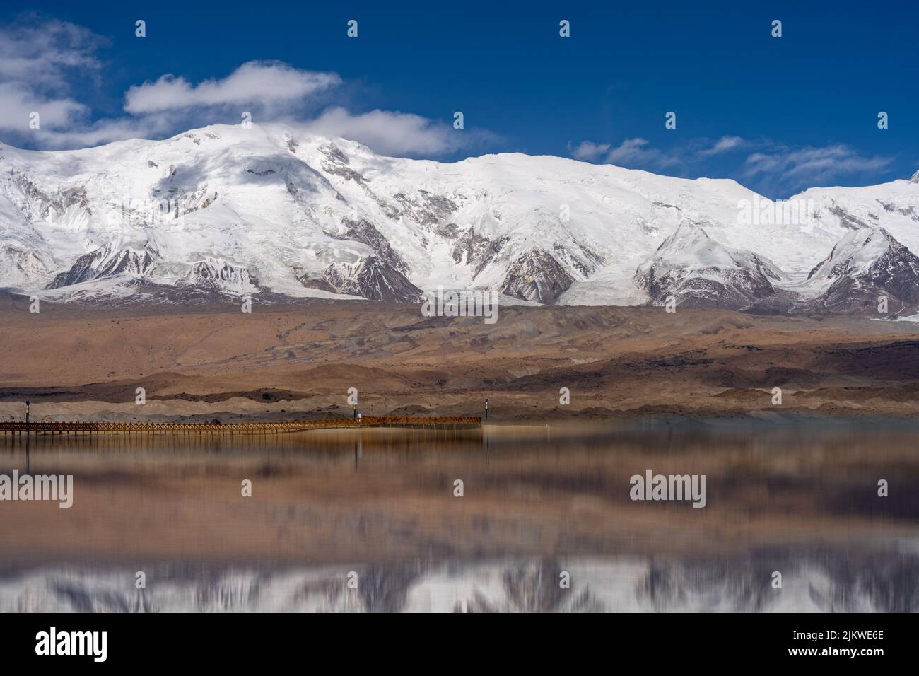 A mesmerizing view of beautiful snow-capped mountains against a cloudy ...
