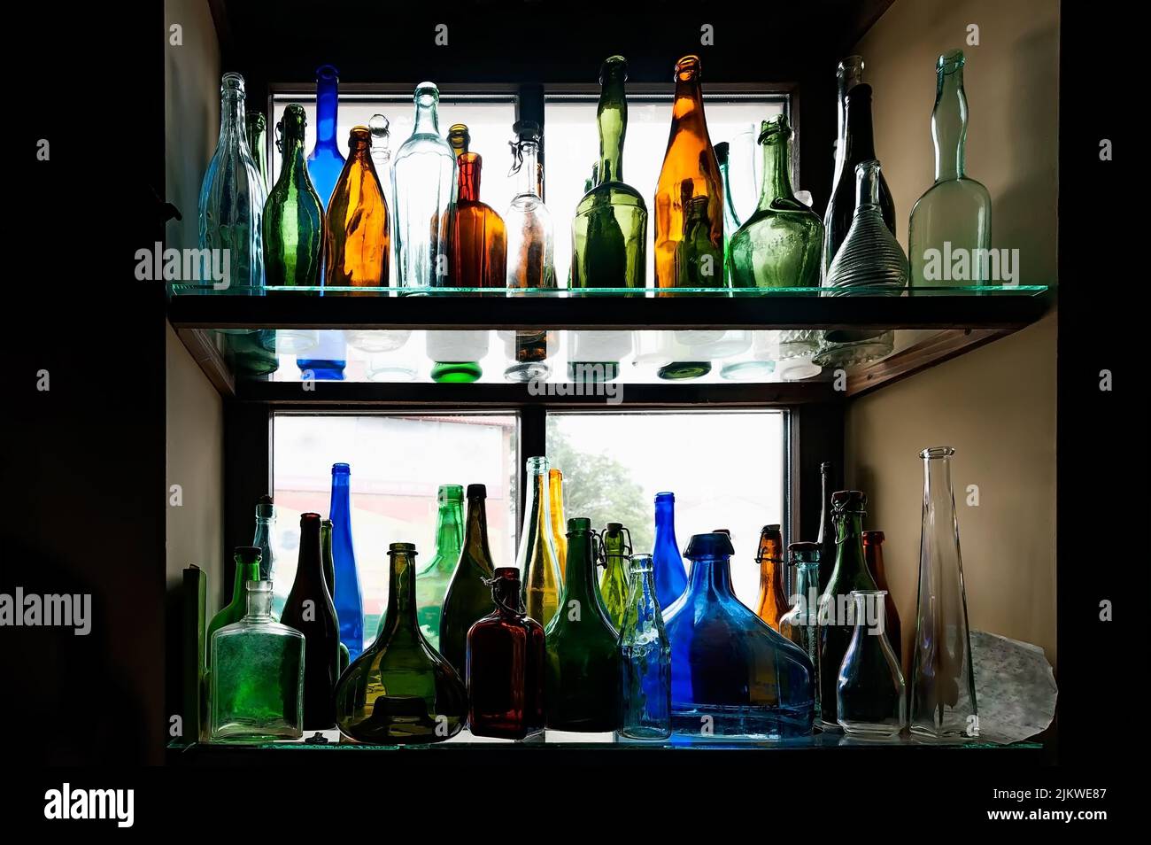 The stack of colorful bottles on a windowsill Stock Photo - Alamy