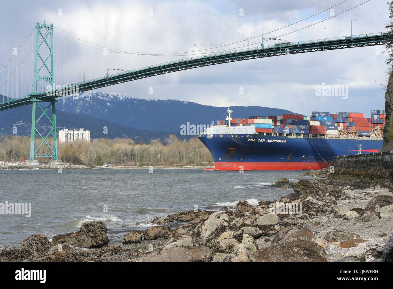 A horizontal shot of a container ship floating in a sea on a background ...