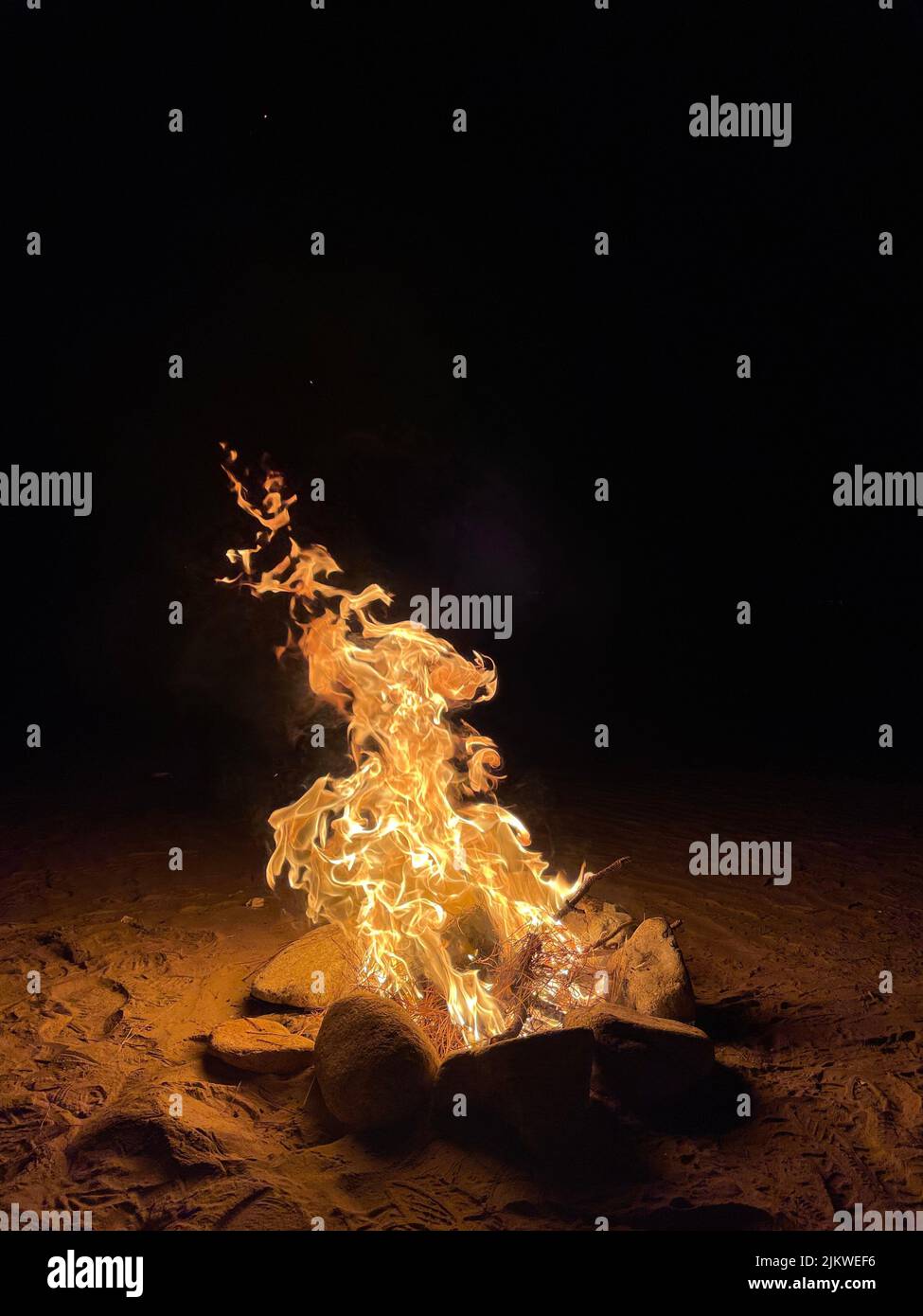 A vertical closeup of the burning flames in the fire camp surrounded by ...
