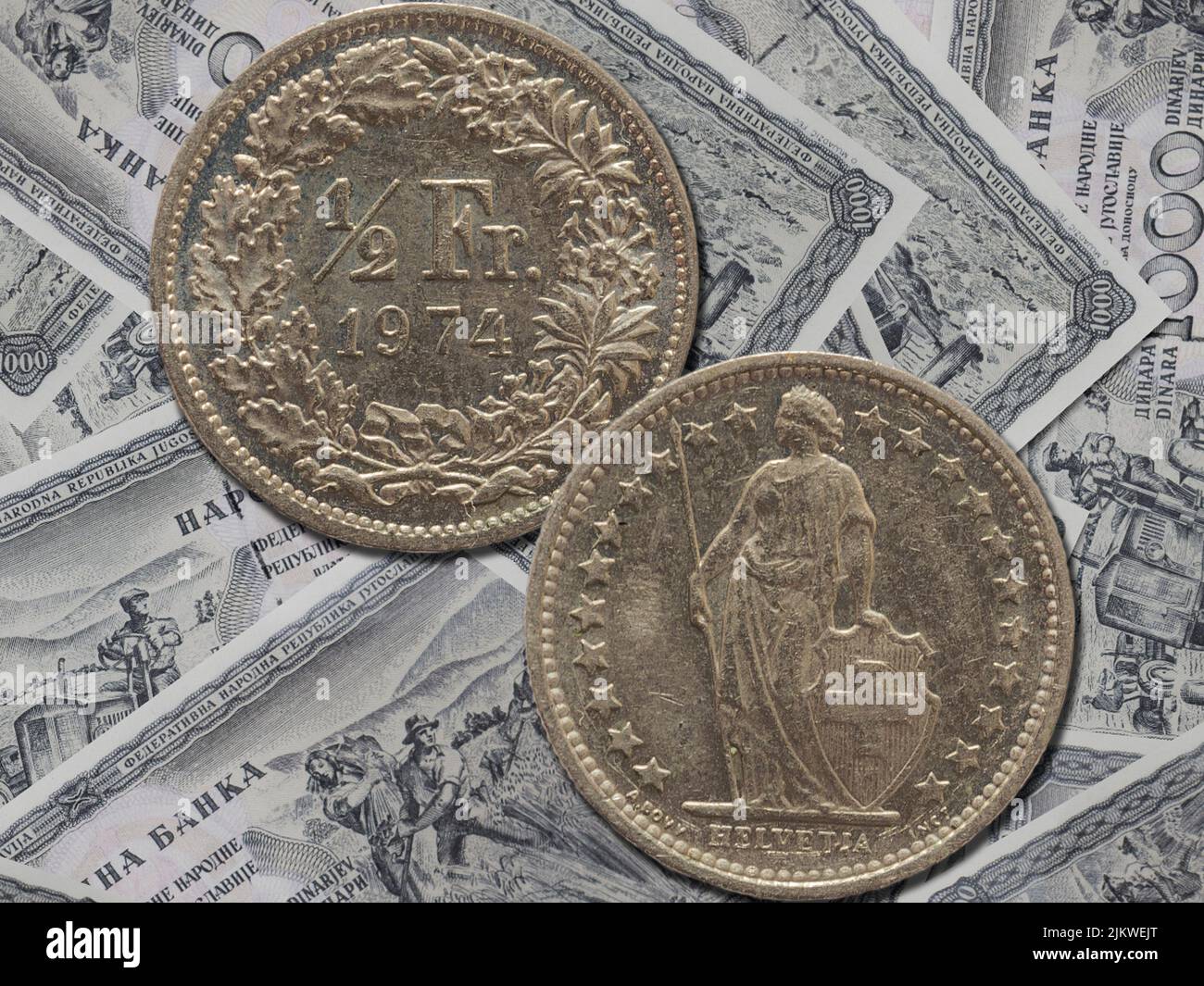 A closeup of vintage Swiss franc coins isolated on paper money ...