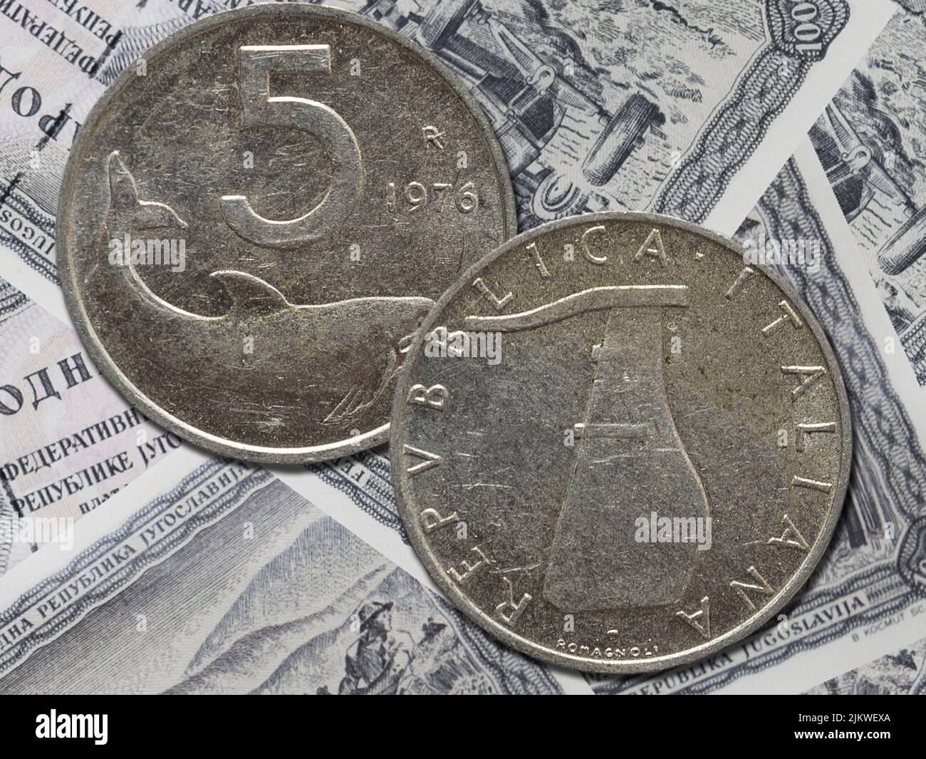 A vintage Italian lira coin from 1976 isolated on a paper money ...