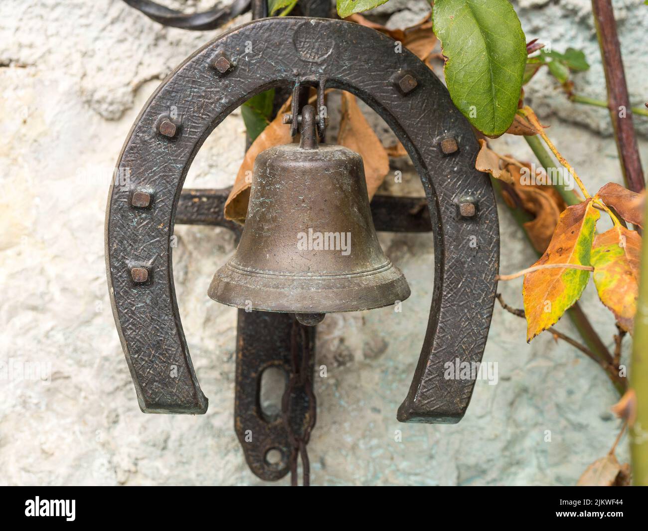 A closeup of a bell against a concrete wall background Stock Photo - Alamy