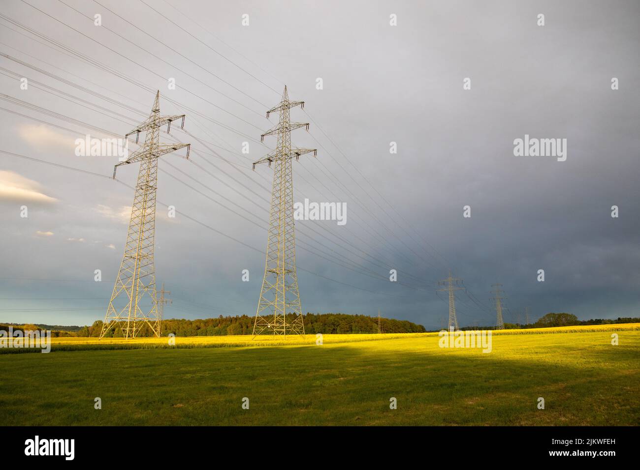 Two pylons in a rural field under a cloudy sky Stock Photo - Alamy