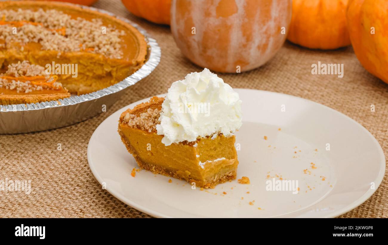 Slice of fresh baked homemade pumpkin pie decorated with crushed nuts ...