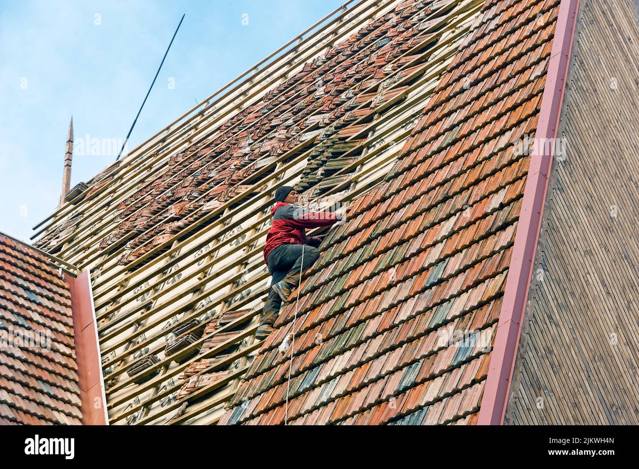 The unidentified roof mechanic, shingler layers tiled roof in the ...