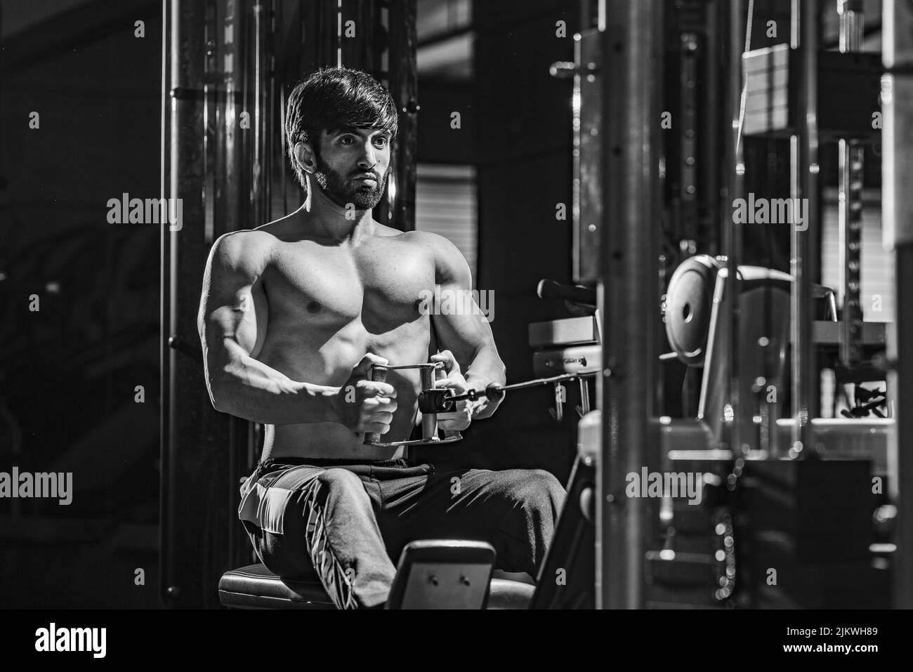 A grayscale shot of a fit athletic muscular Caucasian man working out ...