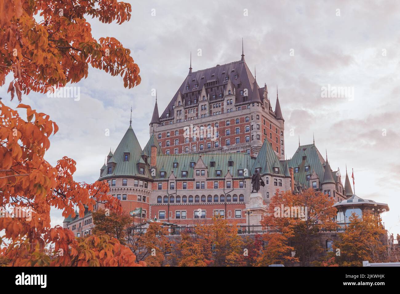 The view of Chateau Frontenac with autumn leaves against the cloudy sky ...