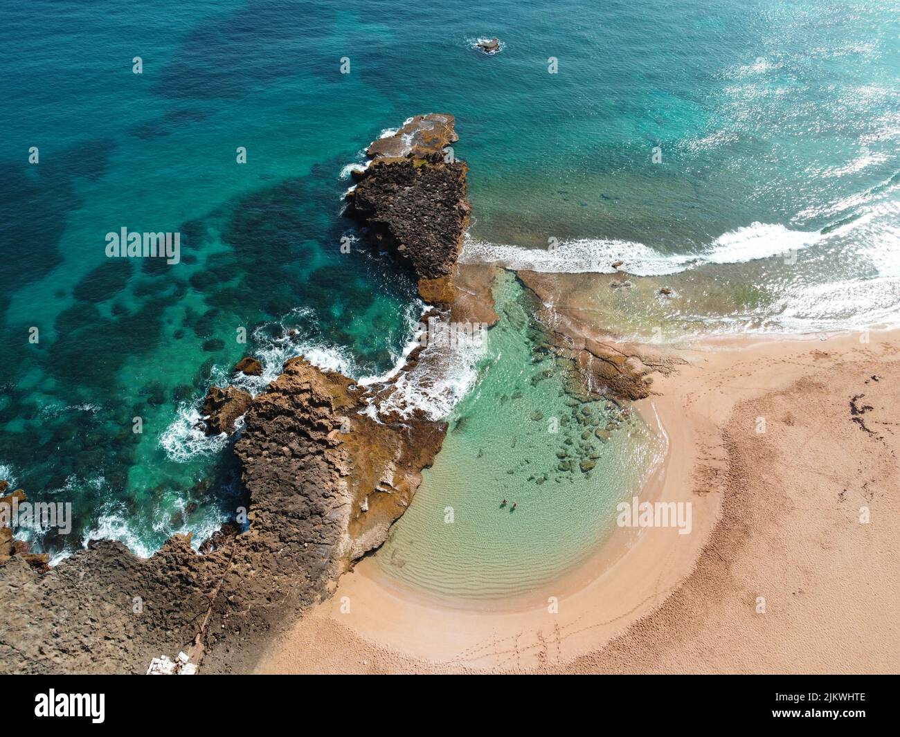 A beautiful aerial top view of a crystal blue beach on huge textured ...