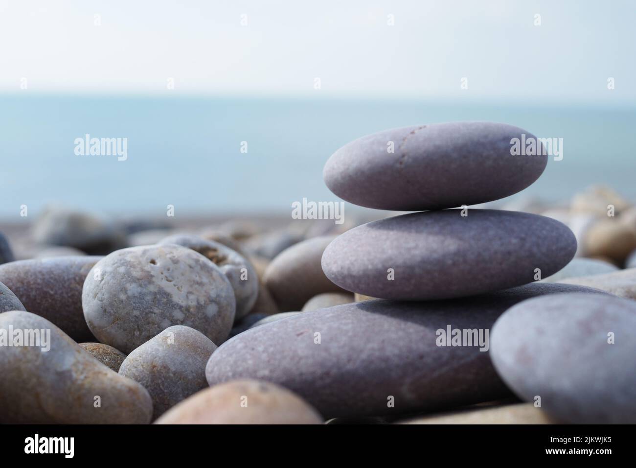 Smooth purple pebbles stacked on pebbly beach in Cornwall Stock Photo ...