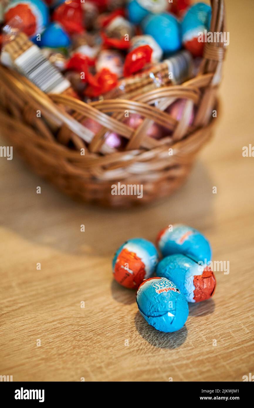 A Kinder brand chocolate eggs and Shoko Bons candies by a basket Stock ...