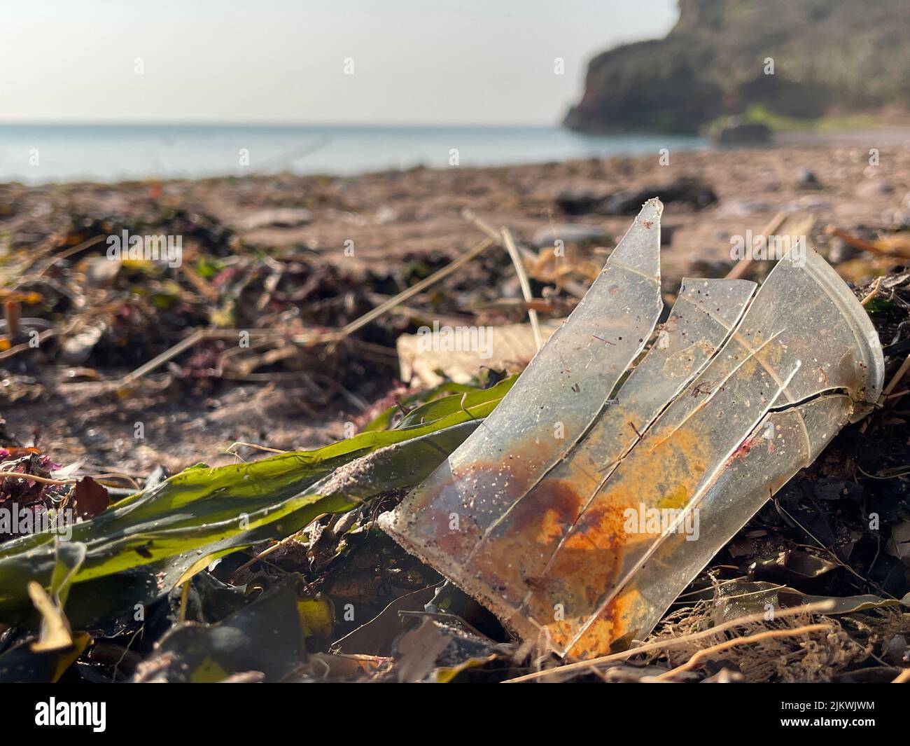 Broken plastic cup pollution on beach in Devon Stock Photo - Alamy