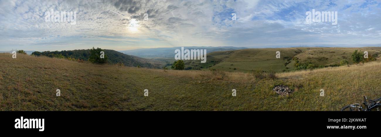 A beautiful panorama of a field in the mountains on a sunny day Stock ...