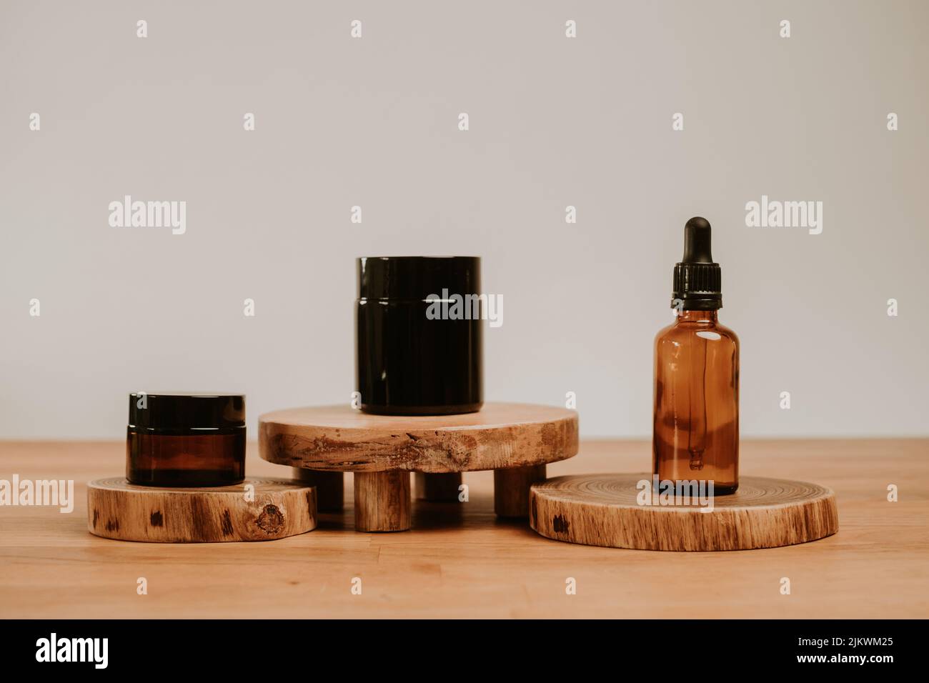 The cosmetic products and serum on the wooden stand isolated on a beige ...