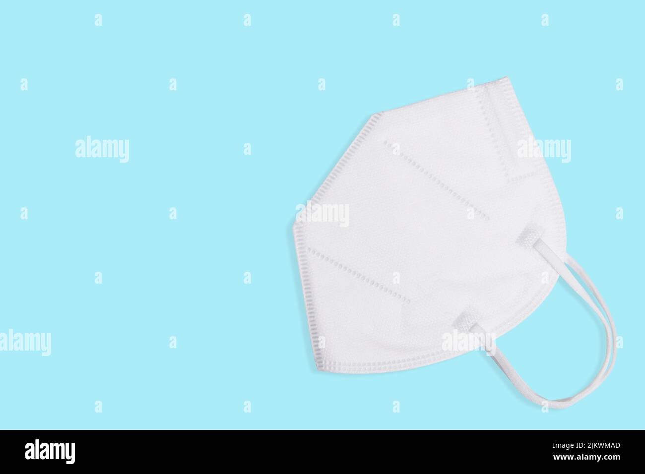 A closeup of a white face mask on a blue background Stock Photo - Alamy