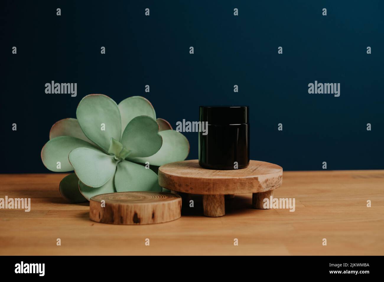 A closeup shot of skin care product's container on a cut tree log as a ...