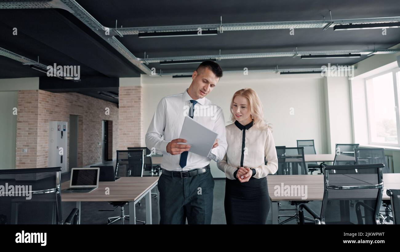 A Caucasian male explaining office rules to a newcomer in the office ...