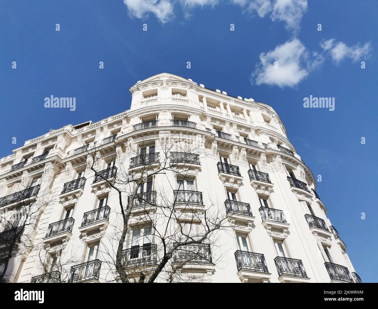 A low angle shot of a typical Spanish white building under a blue sky ...