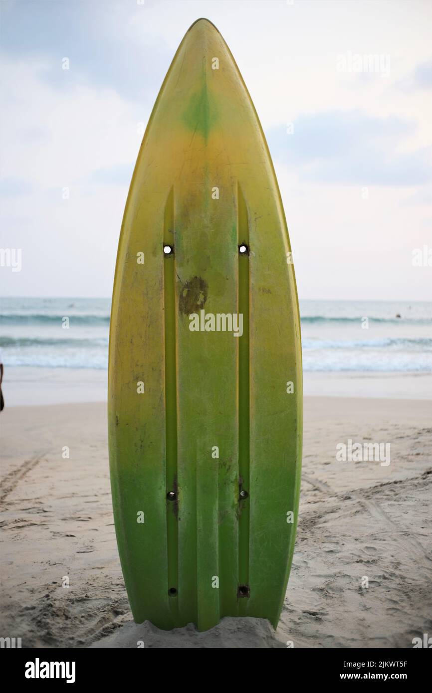 A vertical shot of a green surfboard in Palolem Beach, Goa Stock Photo ...