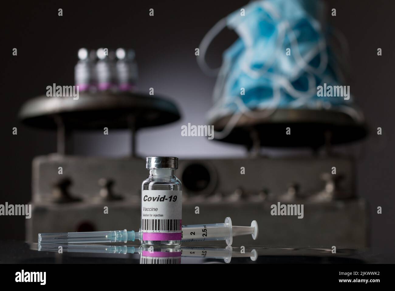 Close up of four ANTICOVID vaccine vials with syringe and surgical ...
