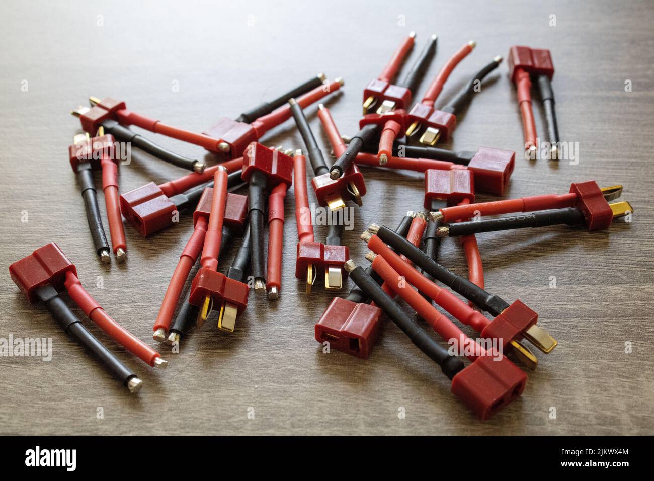 A pile of t-plug battery connector wires on a wooden table Stock Photo ...