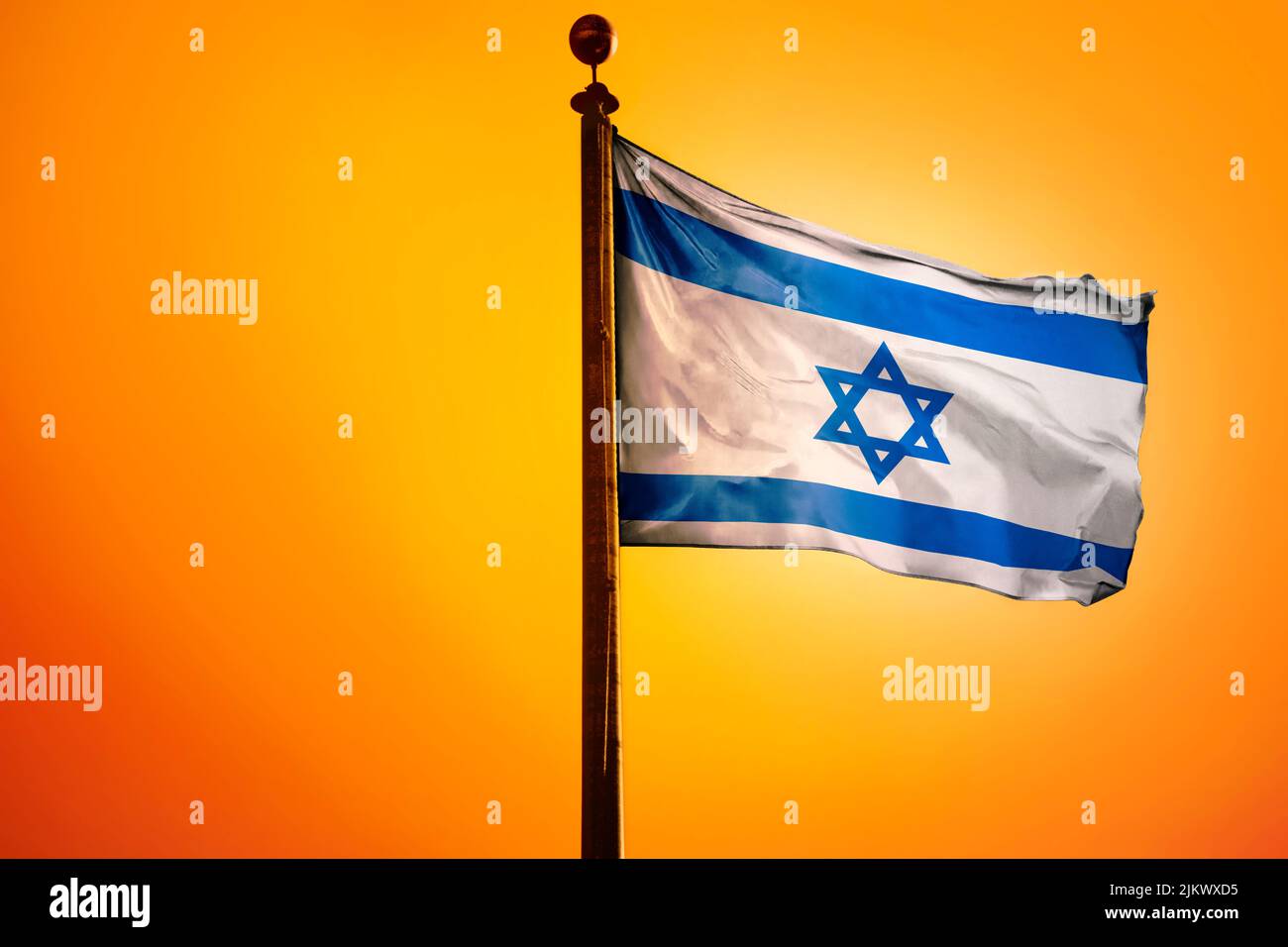 The national flag of Israel on a flagpole isolated on an orange ...
