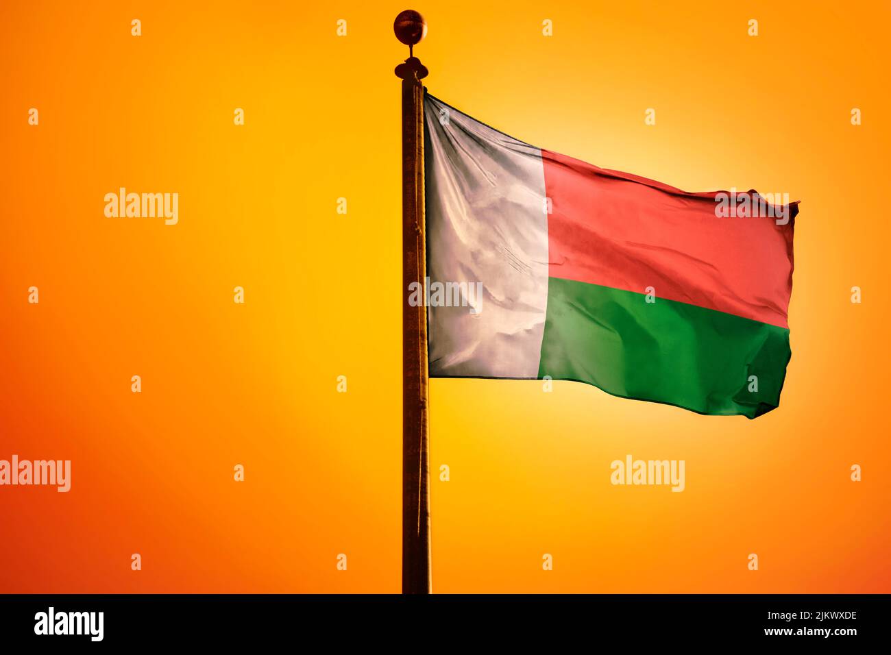 The old flag of Lithuania on a flagpole isolated on an orange ...