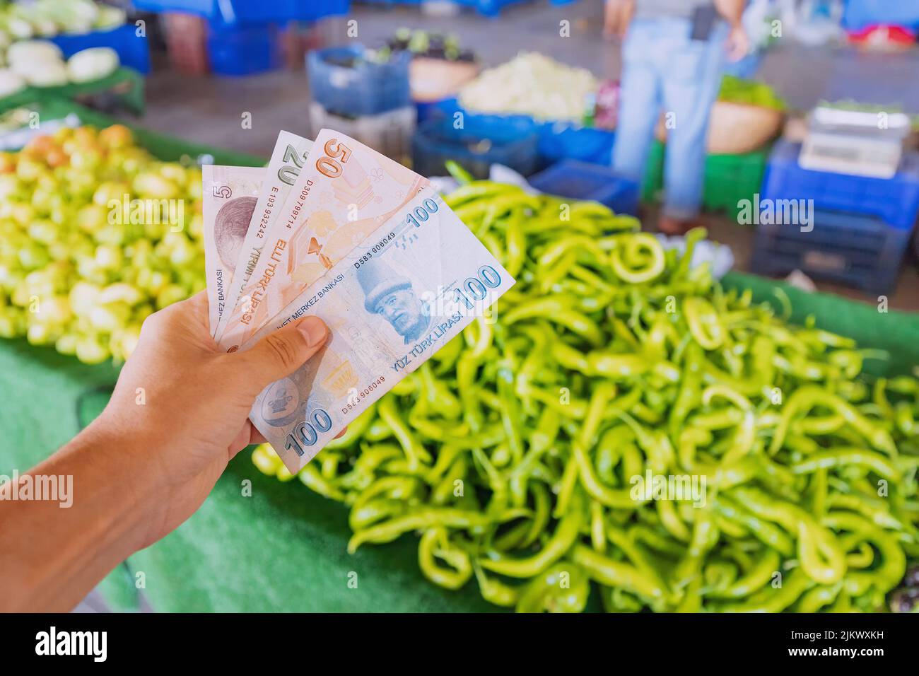 Turkish lira banknotes in hand against the background of vegetables at ...