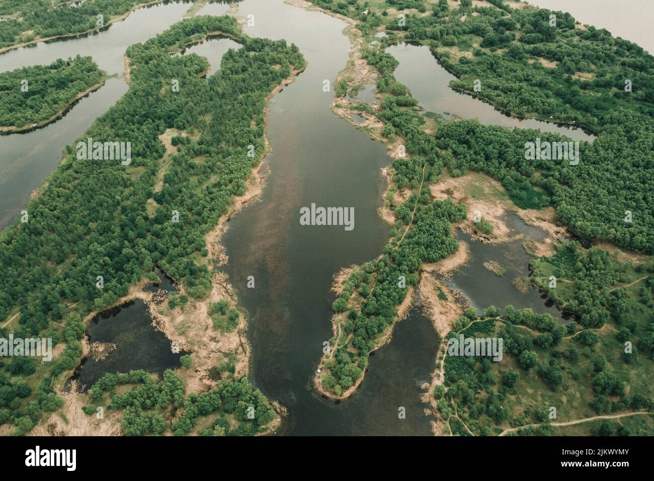 An aerial top view of a landscape covered with lakes and green trees ...
