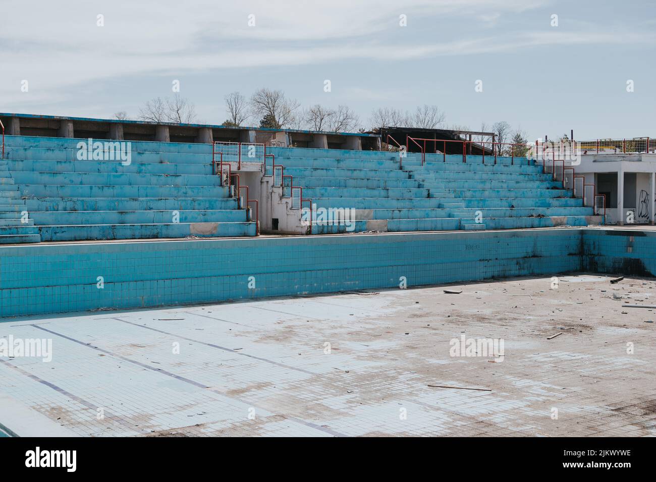 A swimming pool without water and dirty on a sunny day against the blue ...