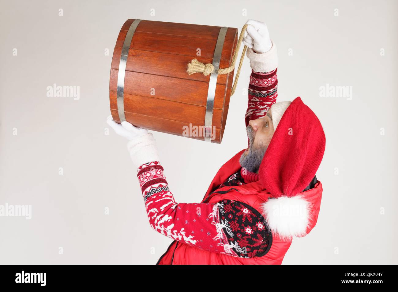 New Year and Christmas concept. Santa Claus drinks from a large wooden ...