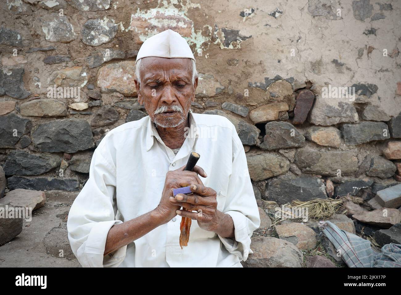 A selective focus of an Indian poor village old man in village attire ...