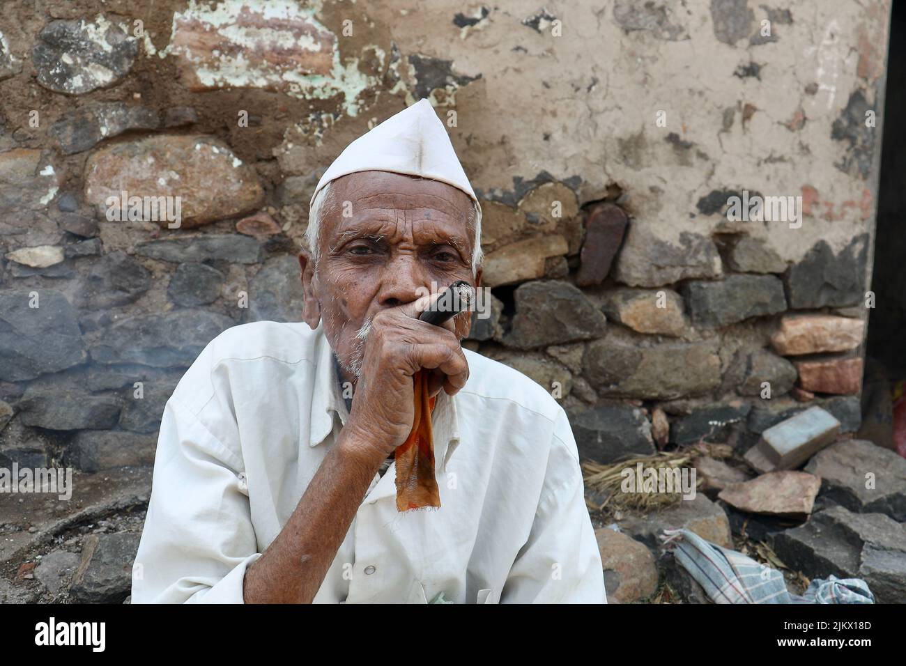 A selective focus of an Indian poor village old man in village attire ...