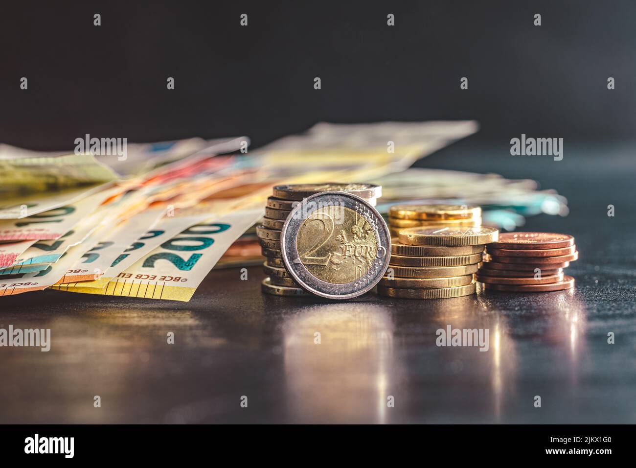 Euro coins on paper euro banknotes on black table Stock Photo - Alamy
