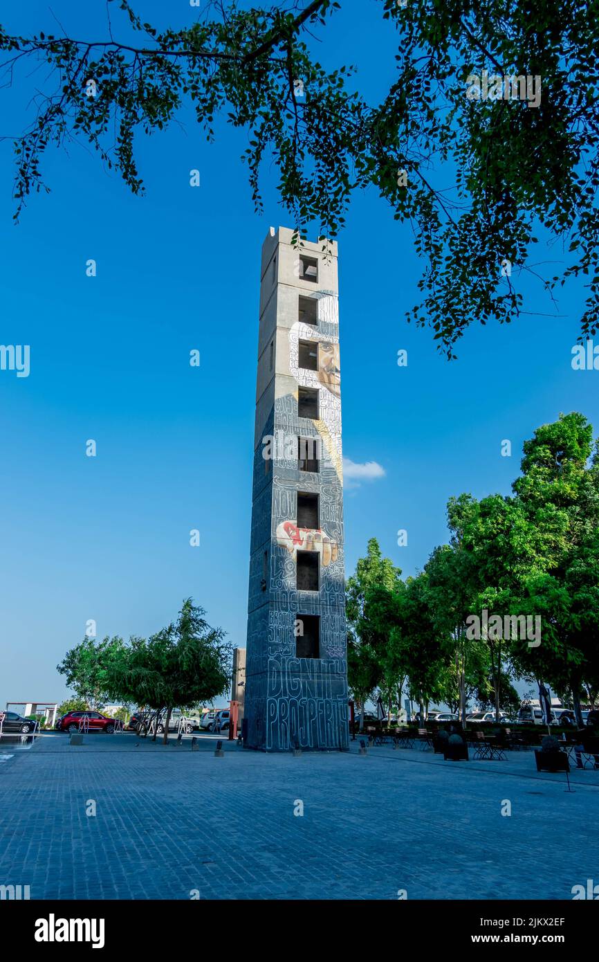 A vertical shot of a tower with a human face drawing in Qatar Stock ...