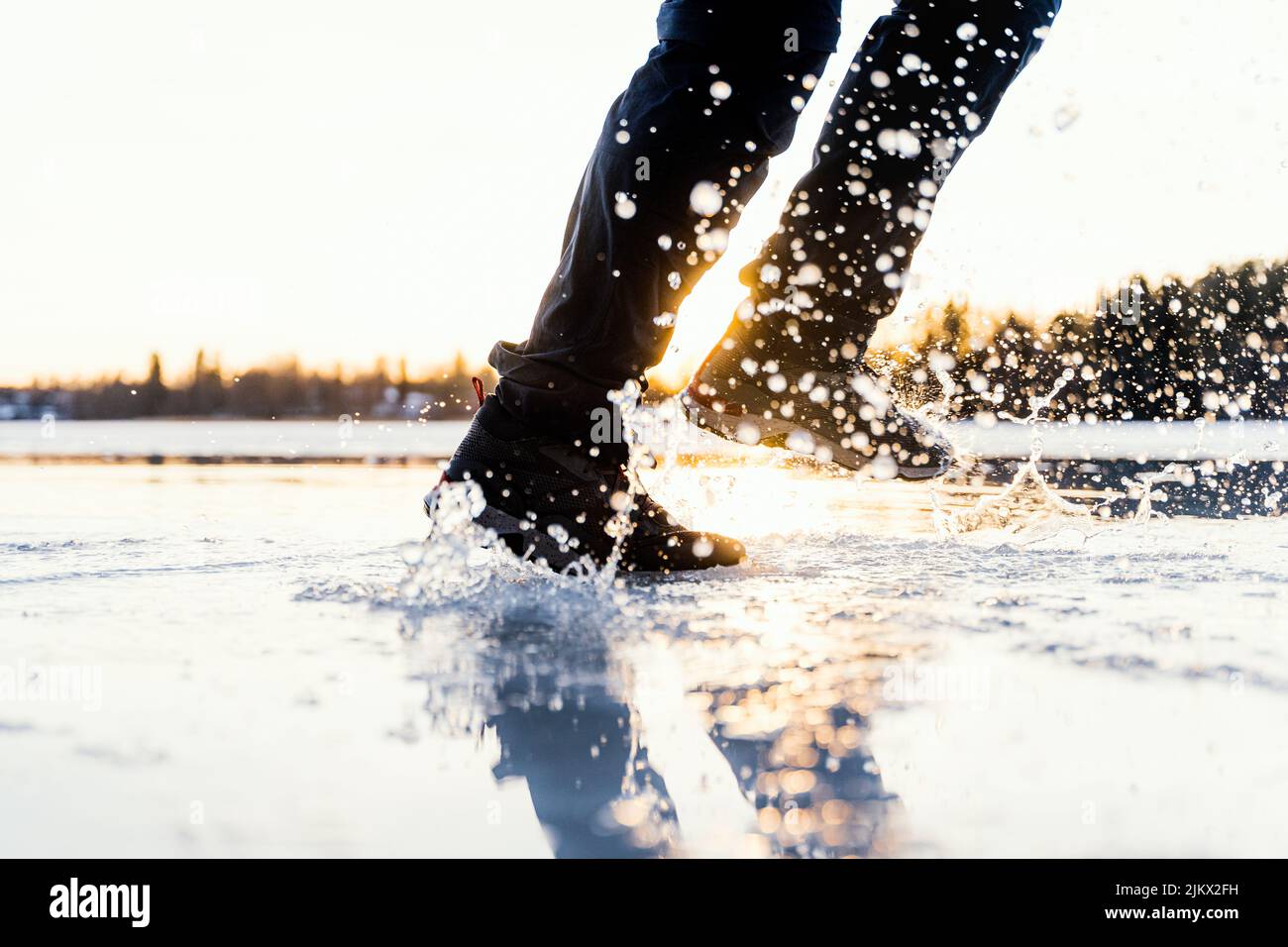 Split second moment while person is running through a water puddle ...