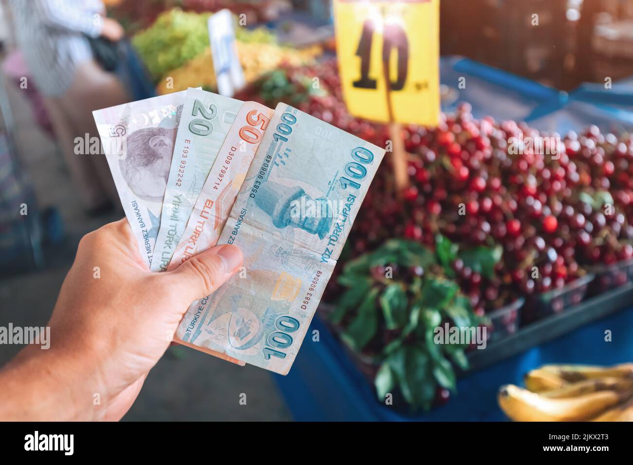 Turkish lira banknotes in hand against the background of cherry for ...
