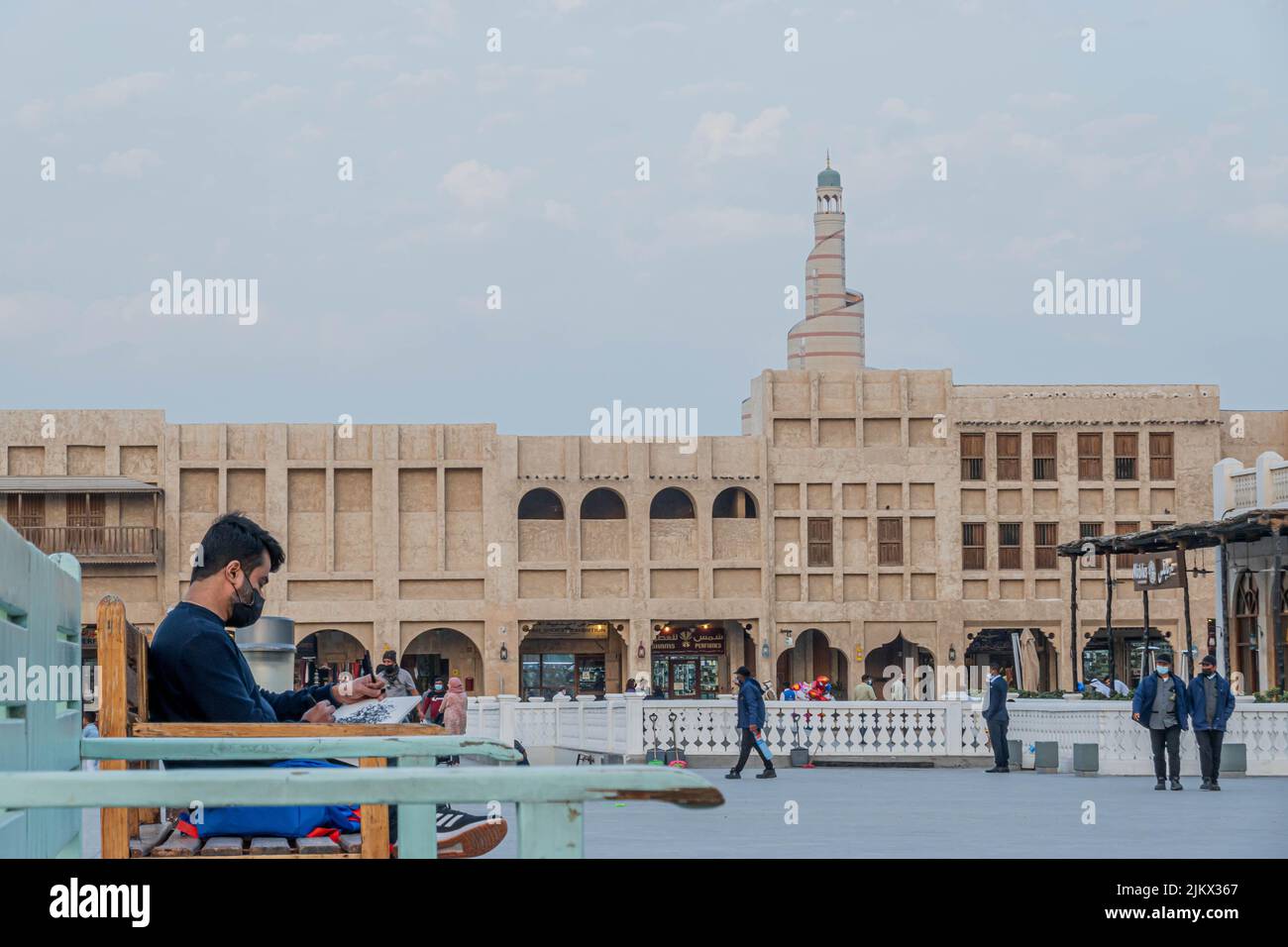 Guy sitting on a bench while sketching in Souq Waqif Doha, Qatar Stock ...
